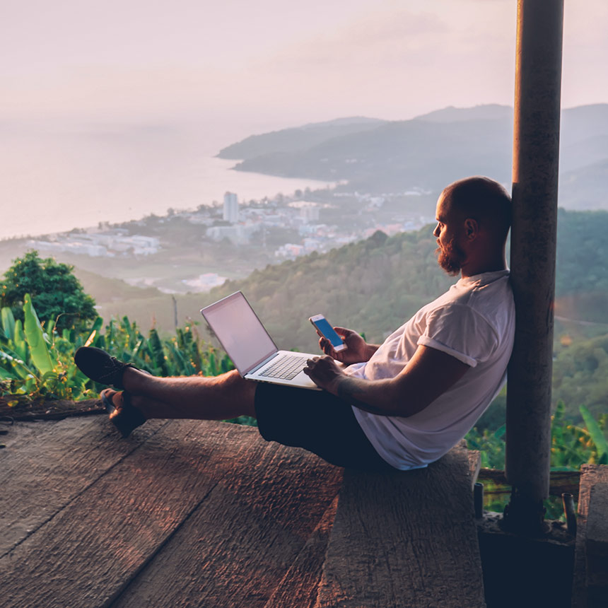 A man on holiday looking at his laptop computer