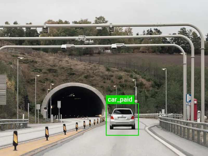 A car at a toll station with a green bounding box around the vehicle ...