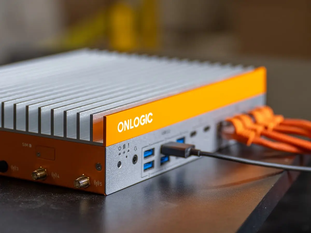 The corner of an OnLogic Helix 521 industrial computer with cables plugged into it.