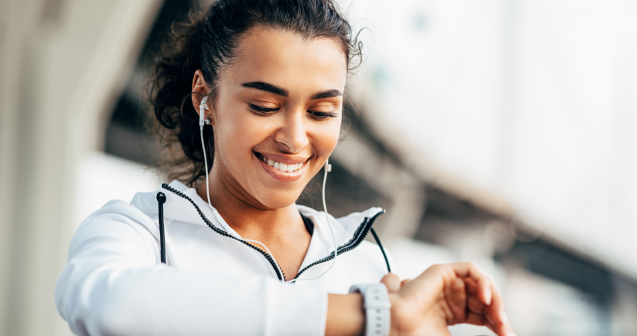 Woman checking her heart rate on smart watch after exercising