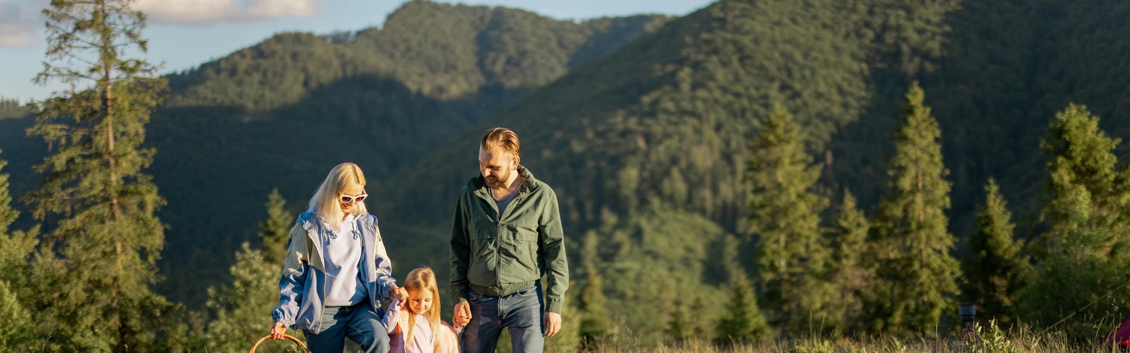 Familj som promenerar i naturen och ler.