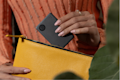 An Tile Slim Black being placed inside of a person's wallet.