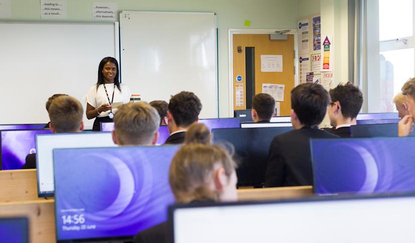 Female teacher stands in front of an IT classroom of secondary school ...