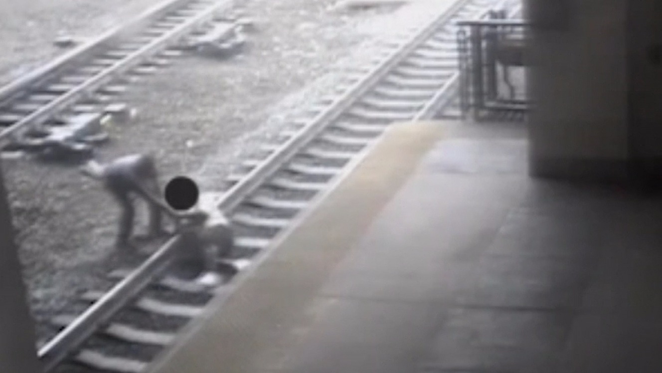 Police officer pulls man off tracks just moments before train speeds ...