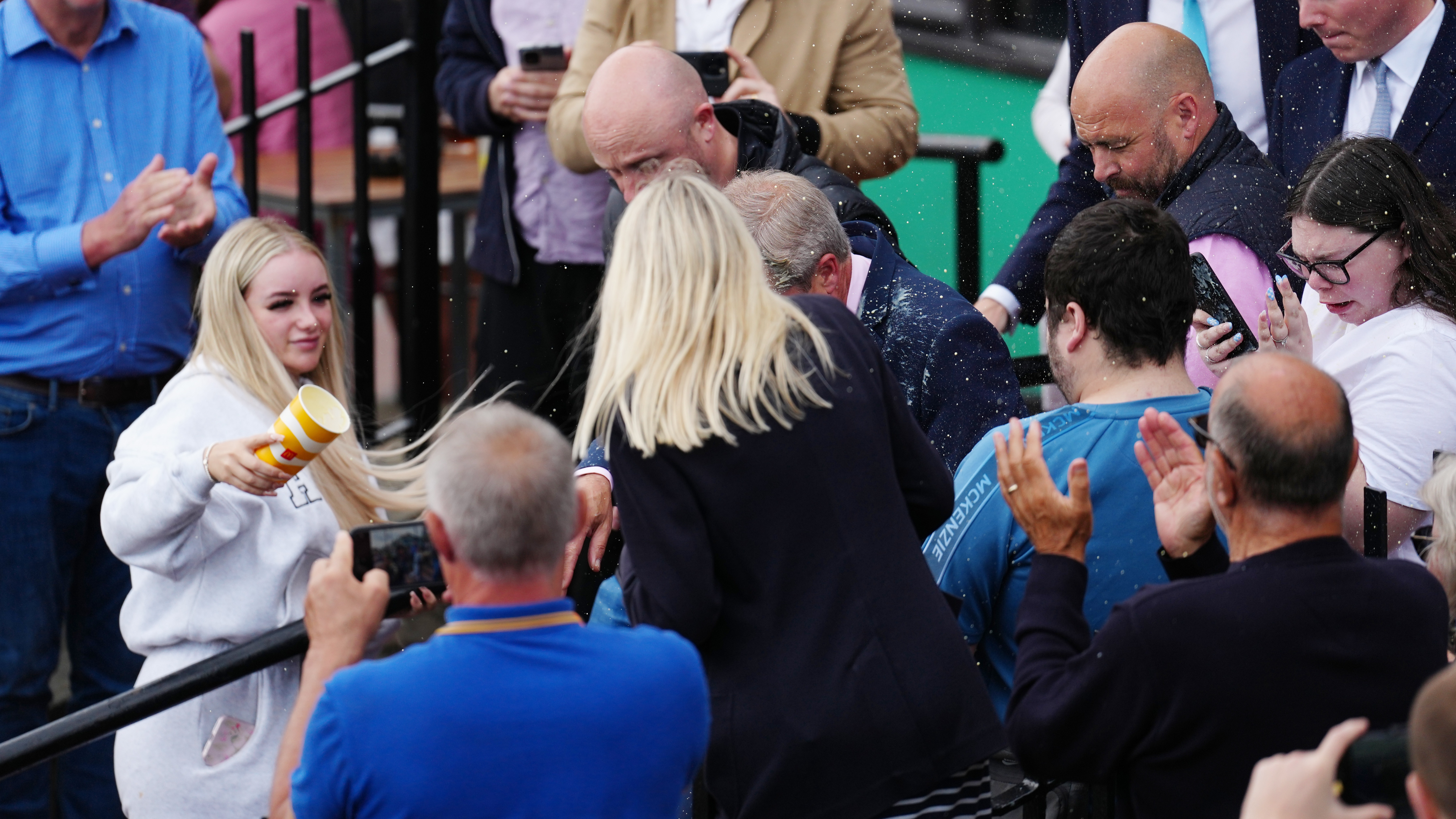 Woman arrested on suspicion of assault after throwing milkshake at ...