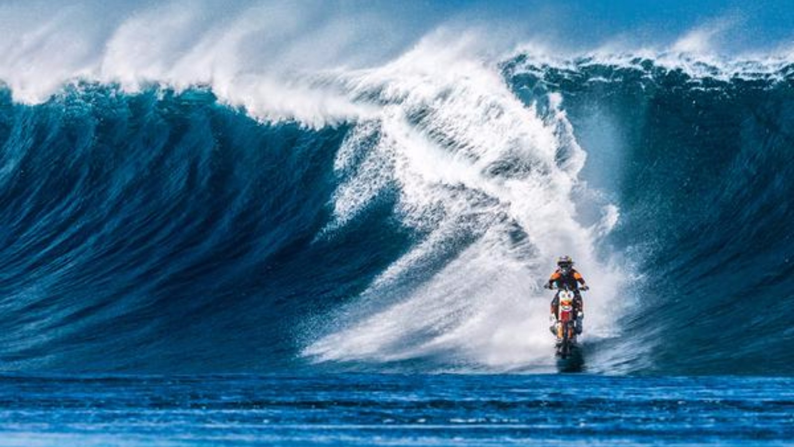Australian stuntman surfs huge wave in Tahiti...on a motorbike | ITV News