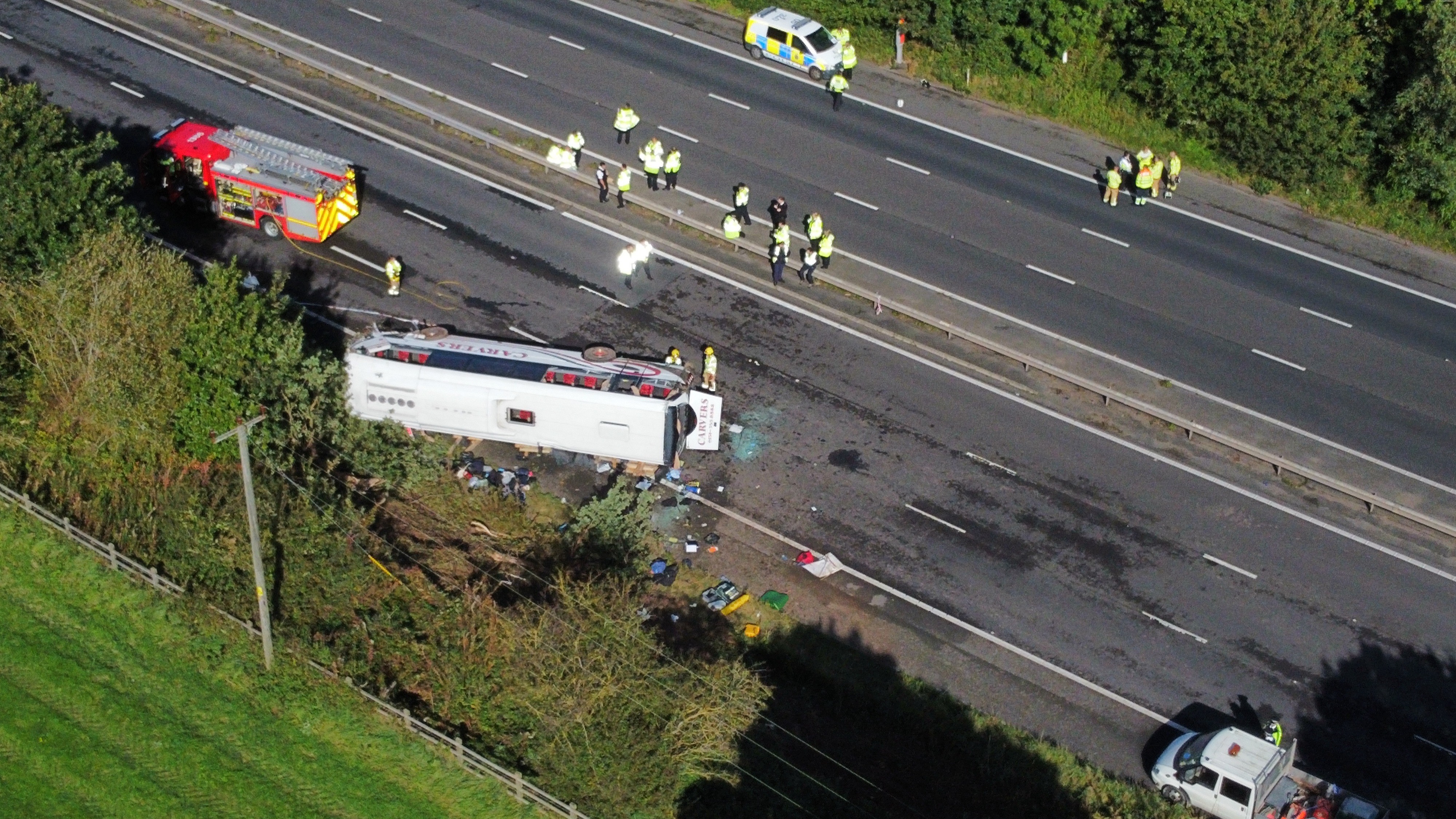 Teenager and coach driver die after school bus left on its side in M53 ...